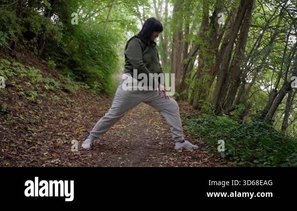 woman lunging through greenery landscape, exercise involving lunging on ...