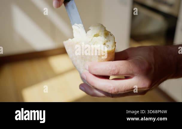 A closeup of hands tearing a freshly baked loaf of bread, showing its ...