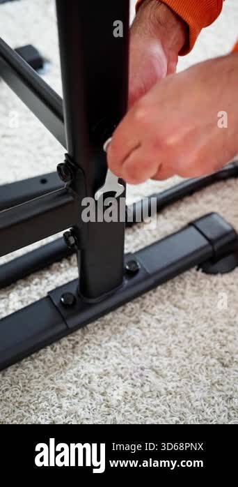 hands assemble metal bed frame latch in bright living room, orange ...