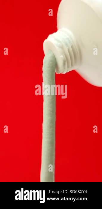 Hair removal cream texture squeezed out of a tube on a red background ...