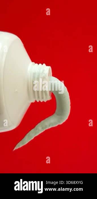 Hair removal cream texture squeezed out of a tube on a red background ...