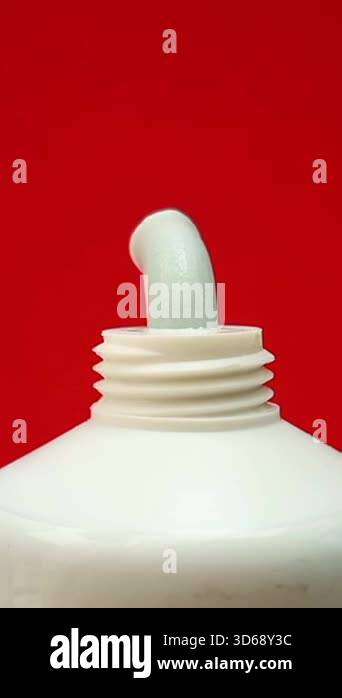 Hair removal cream texture squeezed out of a tube on a red background ...