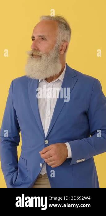 An amazed senior man with a large white beard, wearing a blue jacket ...