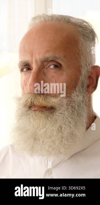 Extreme close-up portrait of a serious senior man with a large white ...