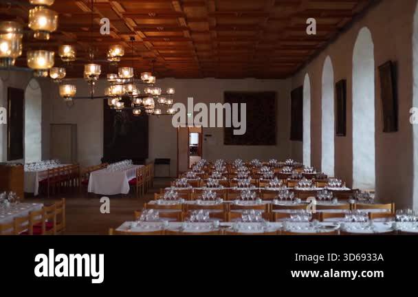 Interior of a medieval castle banquet hall with long wooden tables ...