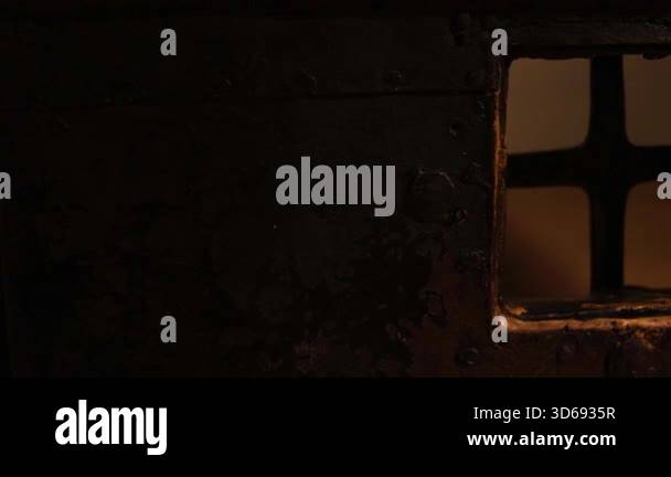 Dark stone prison inside a medieval castle, rusty bars, chains, and ...