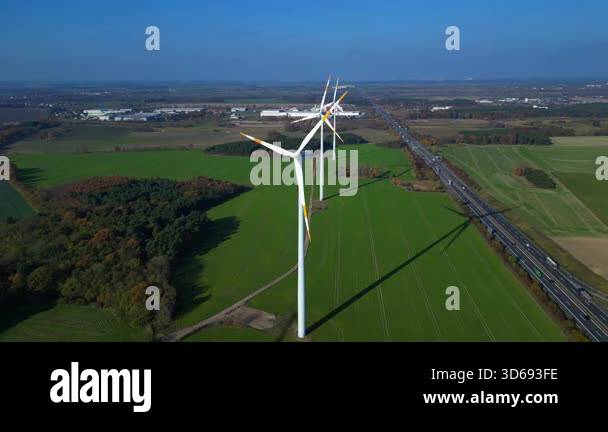 Wind turbine standing in green field next to german autobahn highway ...