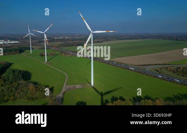 Wind turbine standing in green field next to german autobahn highway ...