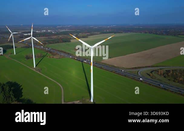 Wind turbine standing in green field next to german autobahn highway ...