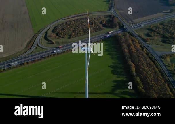 Wind turbine standing in green field next to german autobahn highway ...