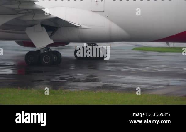 detail of wheel of airplane rolling on the lane before taking off under the rain Stock Video ...