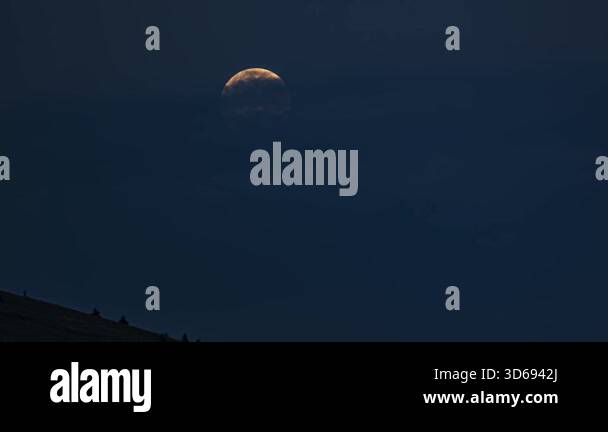 Night sky time lapse of the moon slowly setting behind dark, dramatic ...