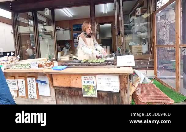 A vendor prepares and sells traditional snacks at a bustling stall in ...