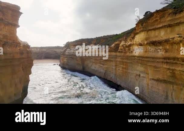 Aerial footage of rugged cliffs and ocean waves at Loch Ard Gorge, Port ...