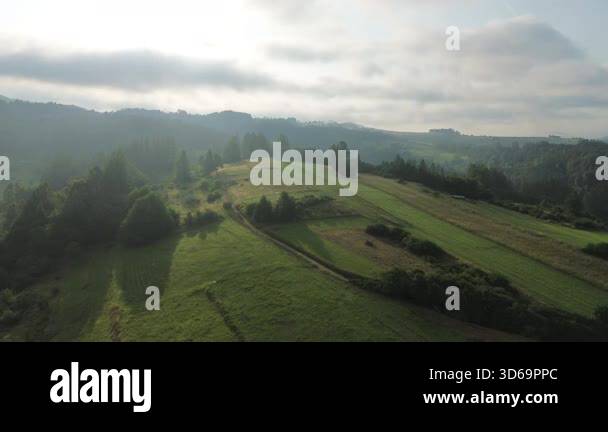 Morning mist over mountain valley village with river Stock Video ...