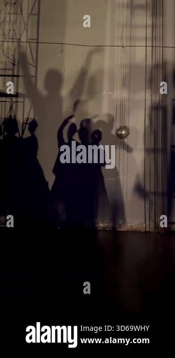 vertical footage of shadows of dancers and stage crews projected on a ...