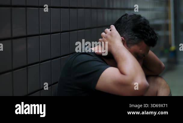 Man sitting with arms folded over head, emotional distress, coping with ...