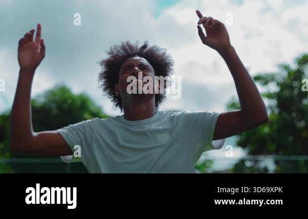 Latin Hispanic man of African descent standing outdoors raising arms ...