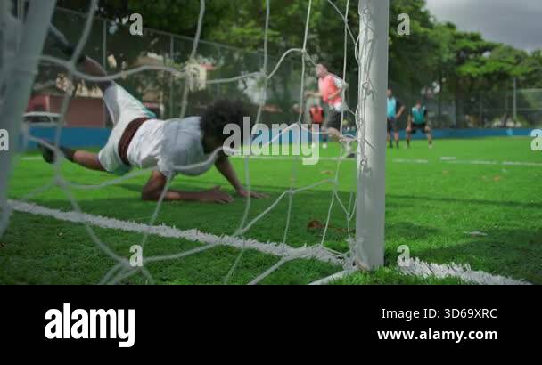 Soccer ball enters goal as African American goalkeeper misses save ...