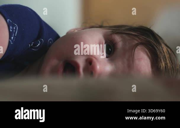 Close-up of baby lying on side, expressive eyes and soft lighting ...