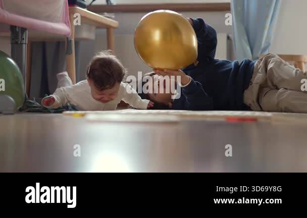 Baby struggling to push forward on floor, showing signs of frustration ...