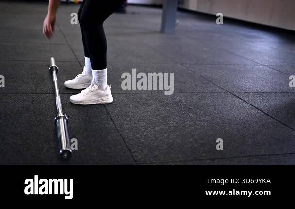 Athlete prepares to lift a barbell in a gym setting. Focus is on ...