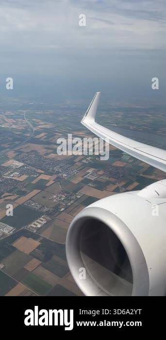 View from airplane window showing aircraft wing and engine flying above ...