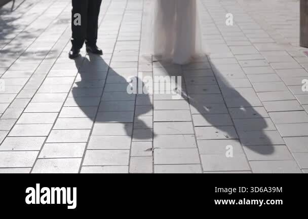 Romantic shot of the shadows of a bride and groom walking together on a ...