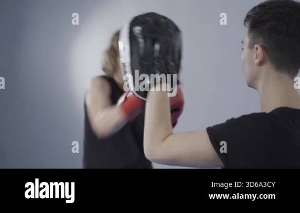 Two sports women training taekwondo punches in training gloves, use ...