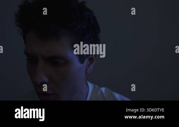 Man wakes up suddenly, holding his chest and breathing heavily in the ...