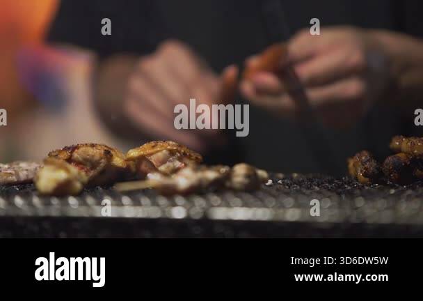 Slow motion howing a cook flipping food on a sizzling hot plate at a ...