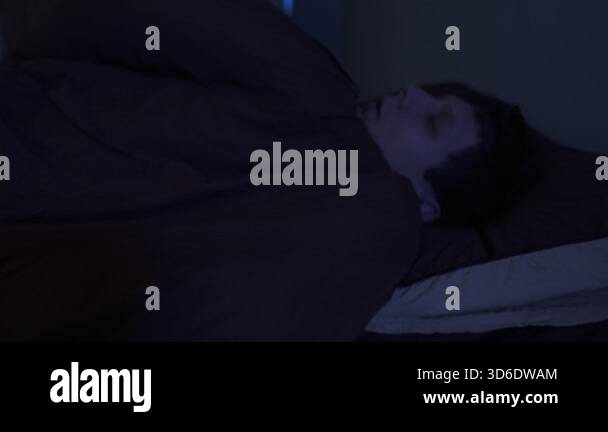 Man wakes up suddenly, holding his chest and breathing heavily in the ...