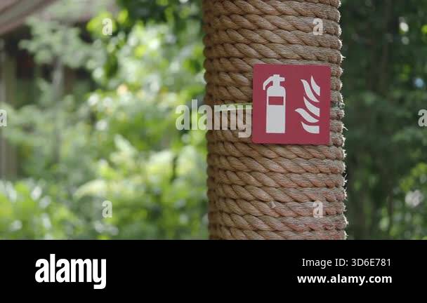 A fire safety sign is visible on a post surrounded by trees Stock Video ...