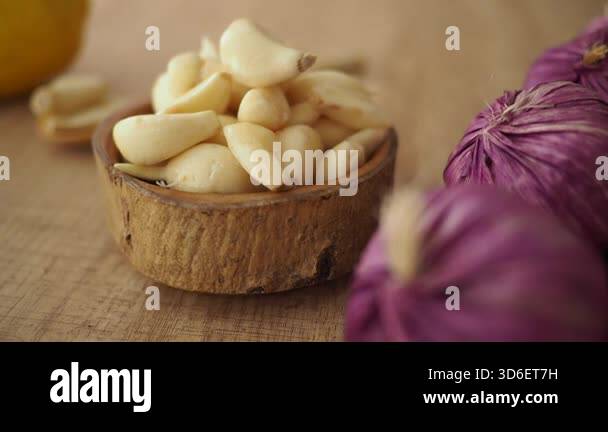 Fresh garlic cloves are shown next to red onions and a lemon Stock ...