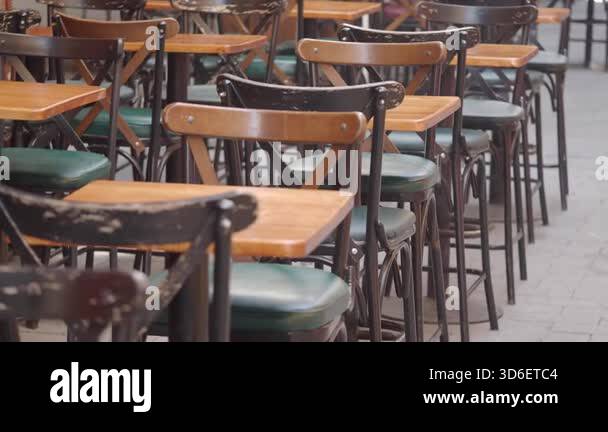 Wooden tables and chairs are arranged neatly in a cafe, waiting for ...
