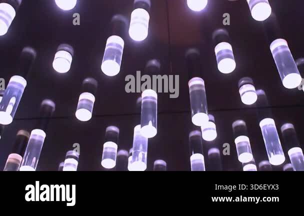 A unique lighting fixture with cylindrical lights hanging from the ...
