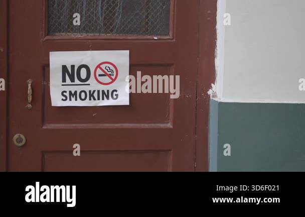 Clear no smoking sign on brown door marks smoke-free area Stock Video ...