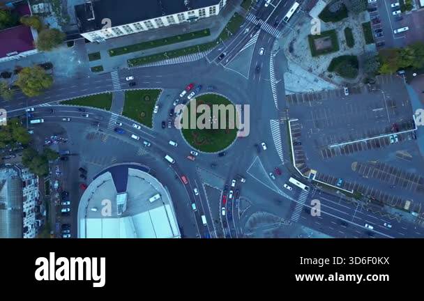 Top down drone view of a busy traffic roundabout in the city at evening ...