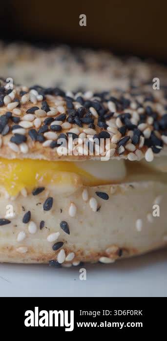 Enjoy a tasty bagel topped with cream cheese and a soft egg yolk Stock ...