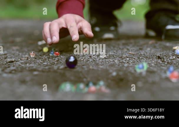 Detail of playing marbles outdoor on dusty way in slow motion Stock ...
