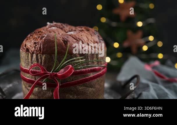 A warm, close-up studio shot of a traditional Italian Panettone cake ...