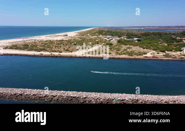 calm ria formosa channel with boat cruising along protected inlet ...