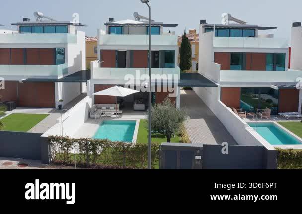 Identical houses with private swimming pools, gardens, and modern ...