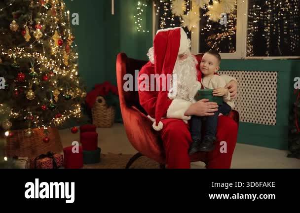 Festive scene of boy hugging santa with gifts, happy child hugging ...