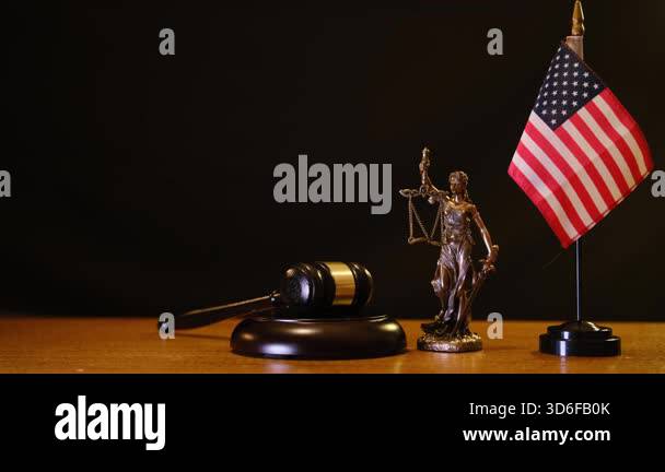 Wooden gavel, Lady Justice statue and American flag on courtroom desk ...