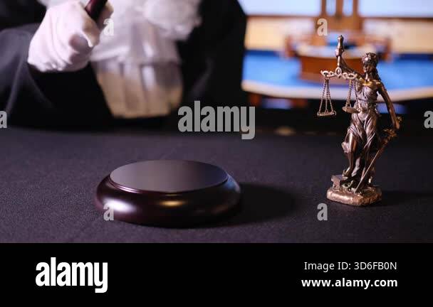 Judge hand with a gavel hitting the sound block next to a justice ...