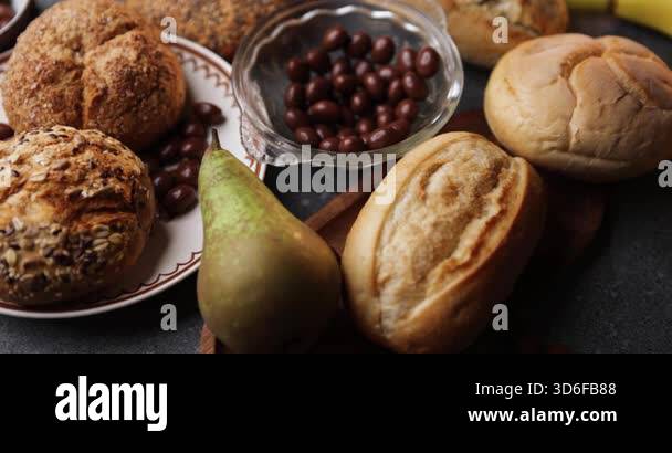 A warm tabletop slider shows crusty buns on a wooden plate beside pears ...