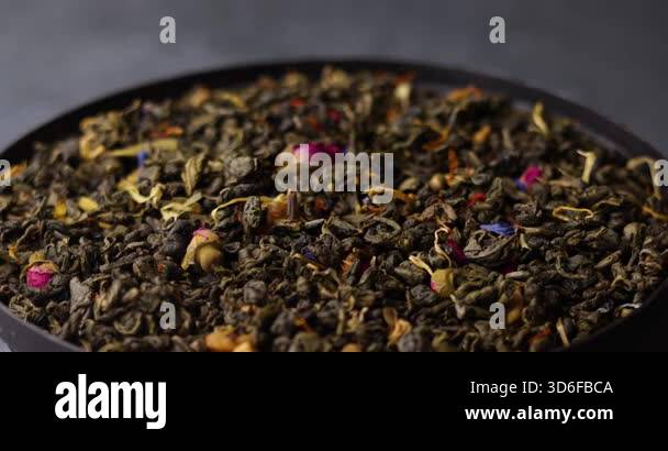 Macro loop video of flavored green tea leaves rotating with tilt shift ...