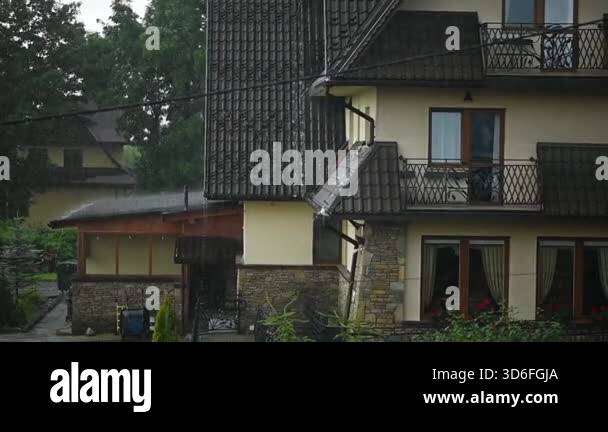 heavy rain drops fall on Traditional house in rural area surrounded by ...