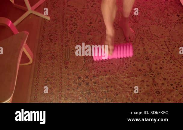 caucasian man stepping and rolling feet over textured foam roller on ...